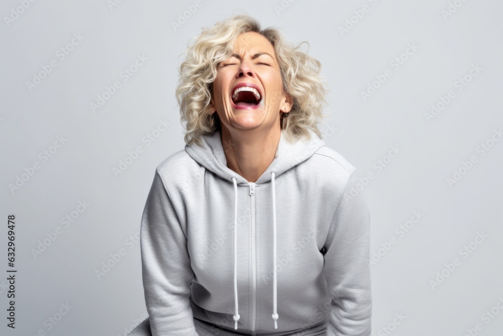 Lifestyle portrait photography of a woman in her 40s wincing with pain ...