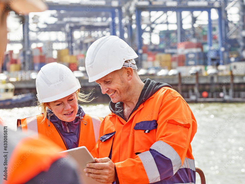 Dock workers communicating with supervisor at docks infront of huge ...