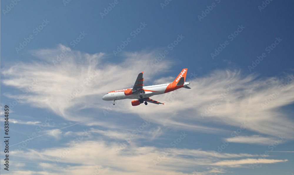 Passenger plane flying in the sky with landing gear below, British ...