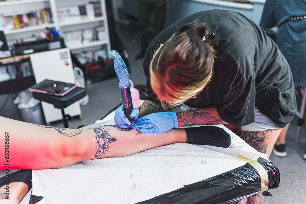 Full focus on work. Raw and real tattooing process photographed in a ...