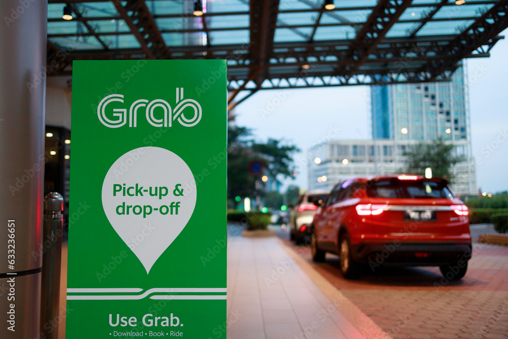 KL, MALAYSIA - 13 JUNE 2023: Grab car pick up and drop off sign at the shopping mall. Grab is a ...
