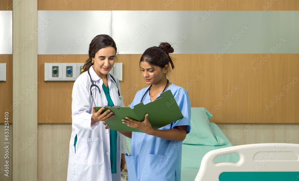 Two healthcare professionals clad in medical uniform amid their ...