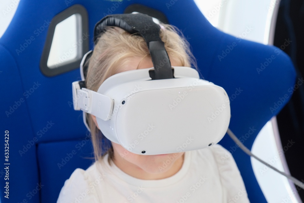 A little girl is playing a VR game in a capsule. VR glasses. Watch a ...