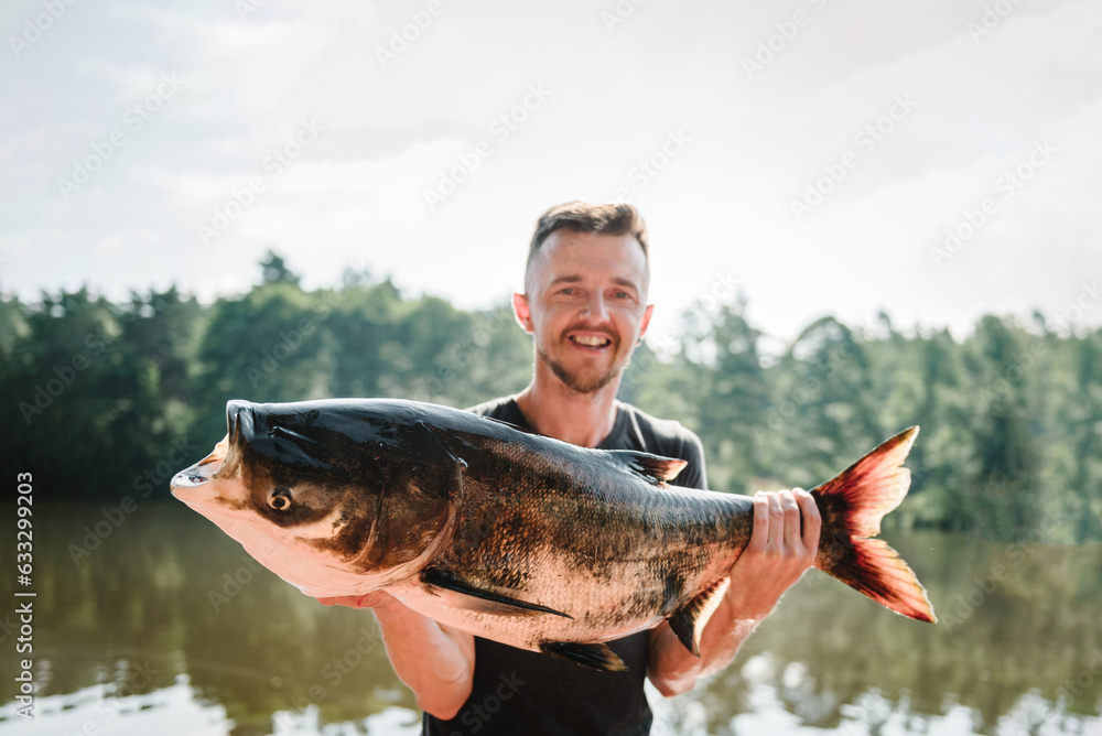 Fresh fish trophy in hands. Young man returning with freshly caught ...