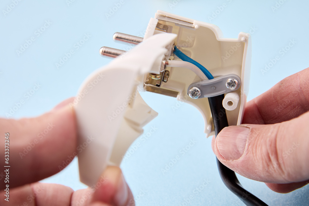 DIY installation of folding electric plug on an electric cord. Stock ...