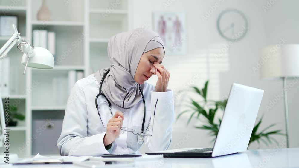 Overworked muslim female doctor suffering from fatigue and headache ...