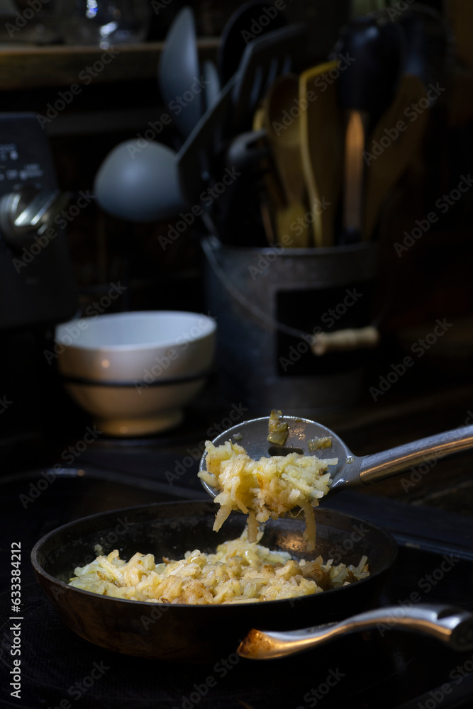 Poster Shredded hash browns cooking in cast iron skillet – Wall Art ...