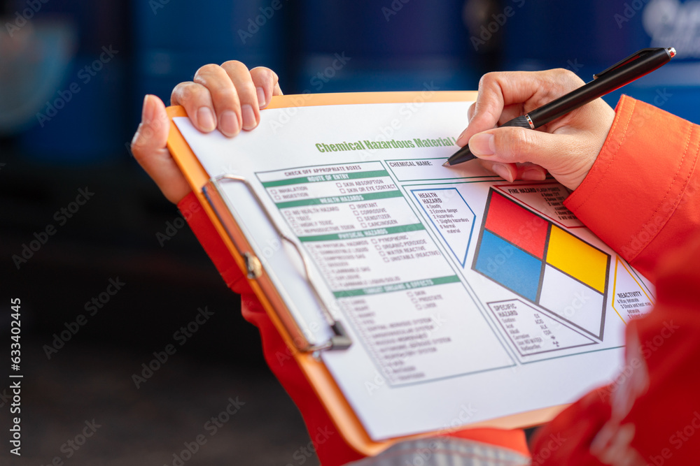 A safety officer is checking on the hazardous material checklist form ...