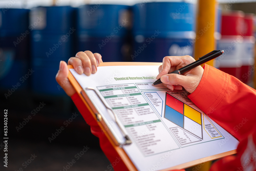 A safety officer is checking on the hazardous material checklist form ...