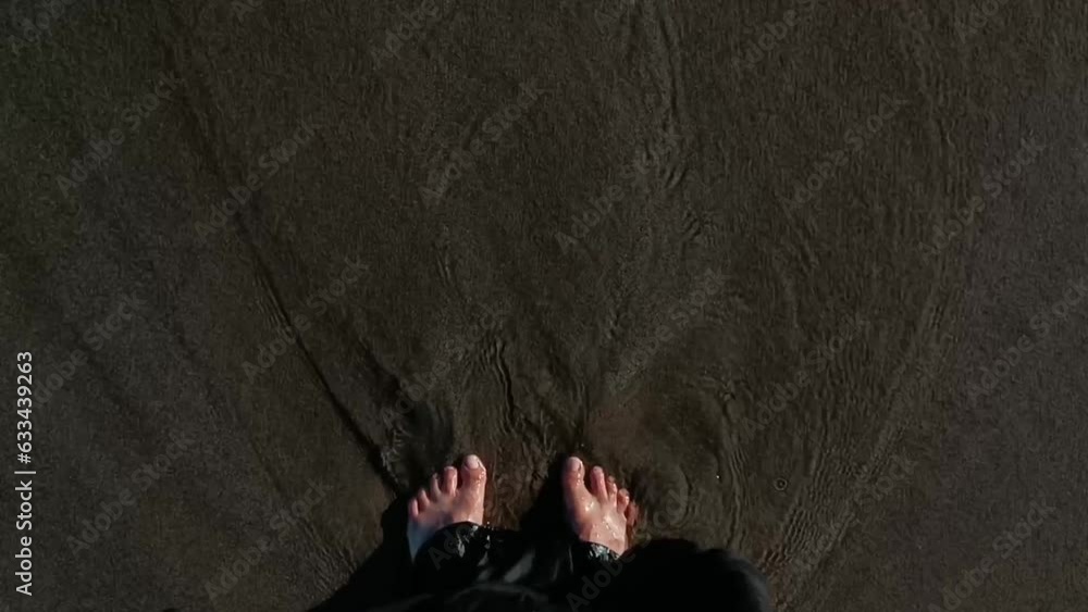 Women's feet on a sandy beach view from above. Feet with a natural ...