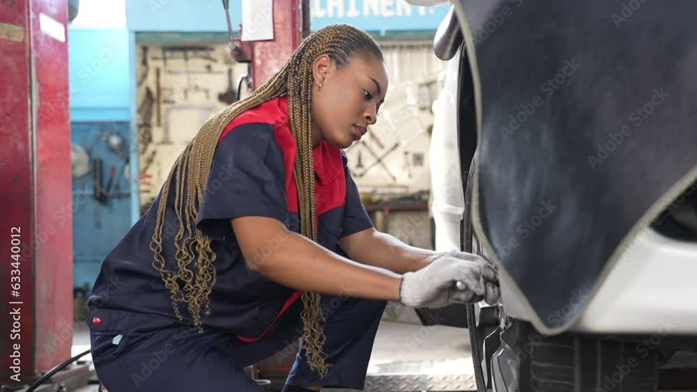 Selective focus and side view of a young African female mechanic in ...
