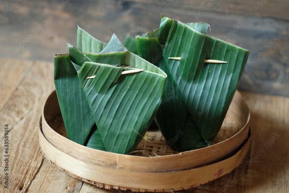 two banana leaf wrapper on a woven bamboo container. in some Asian ...