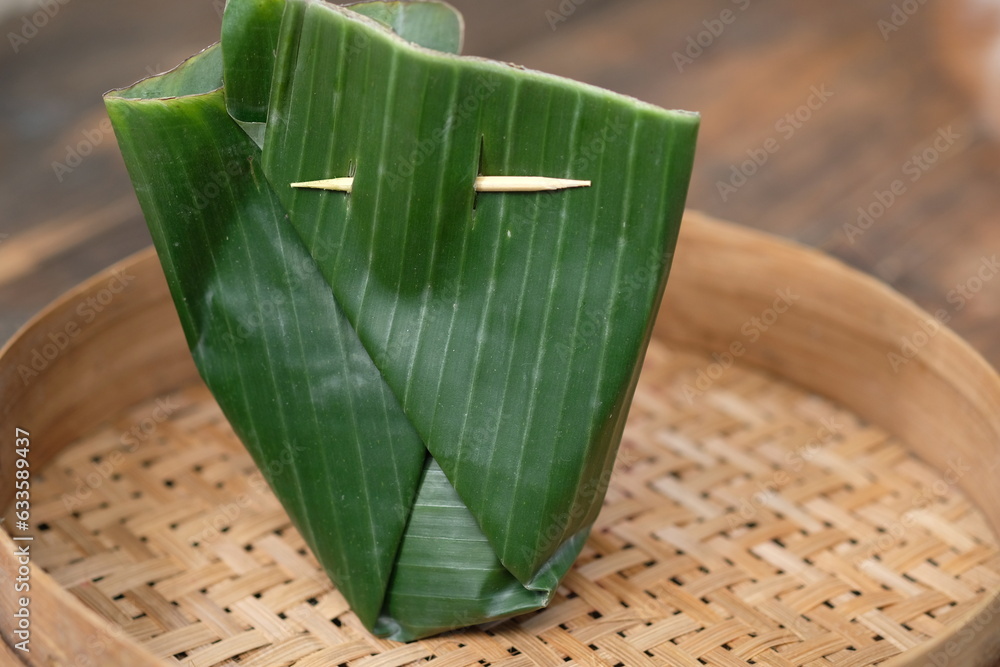 two banana leaf wrapper on a woven bamboo container. in some Asian ...