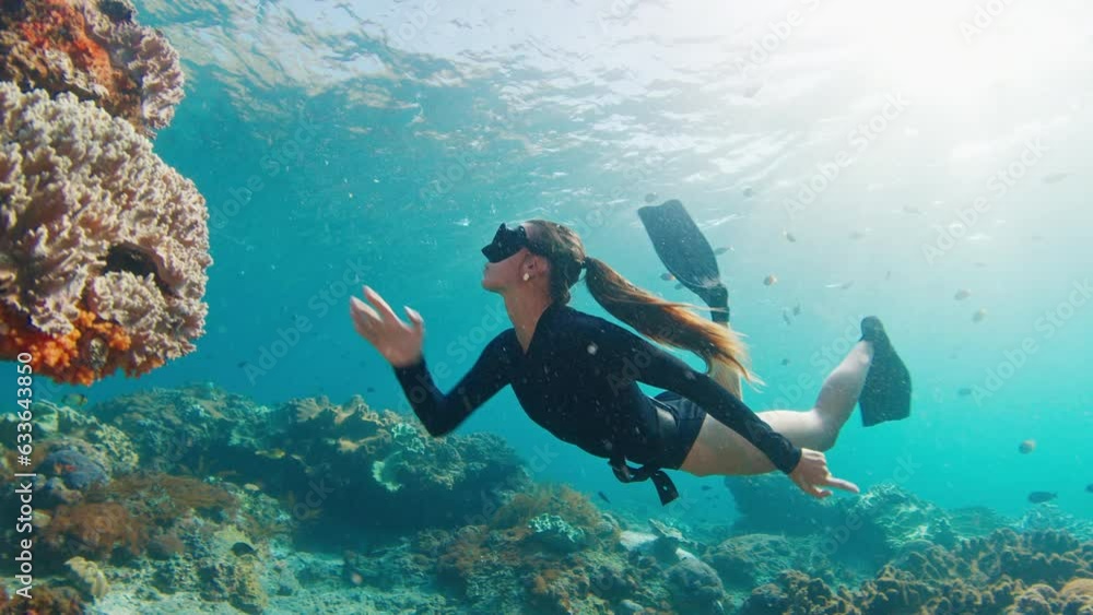 Woman freediver enjoys swimming on the reef. Young female freediver ...