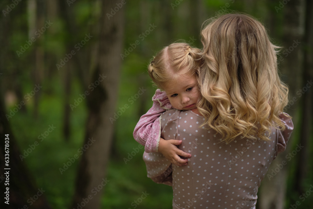Even in vastness of a verdant park, gentle embrace of child to her ...