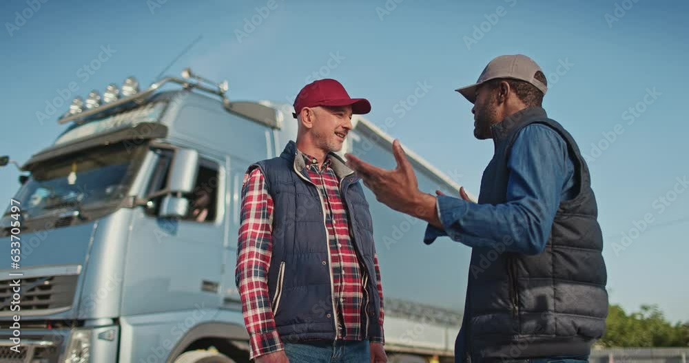 Couple of lorry drivers telling jokes to each other at their parking ...