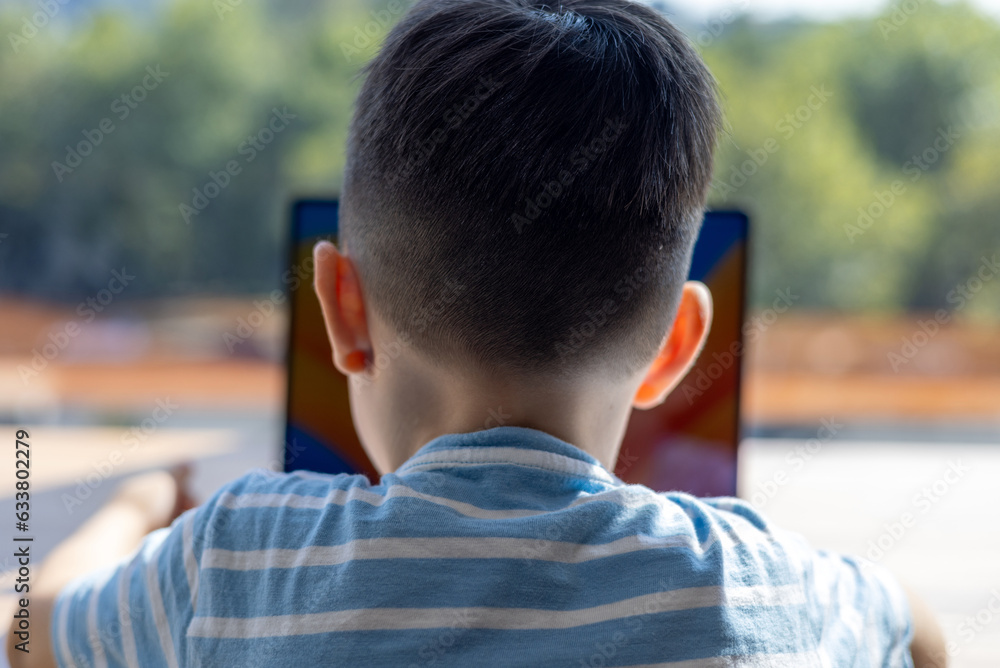 preschooler kid boy sitting at high bar table in food court with laptop ...