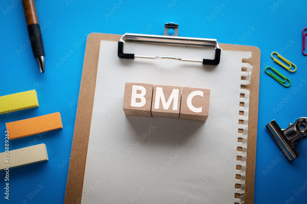 There is wood cube with the word BMC. It is an abbreviation for Business Model Canvas as eye ...