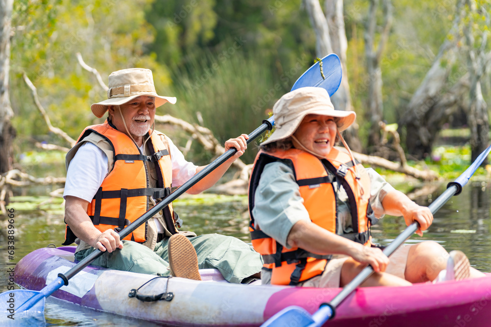 Asian senior couple kayaking together in the lake at mangrove forest on ...