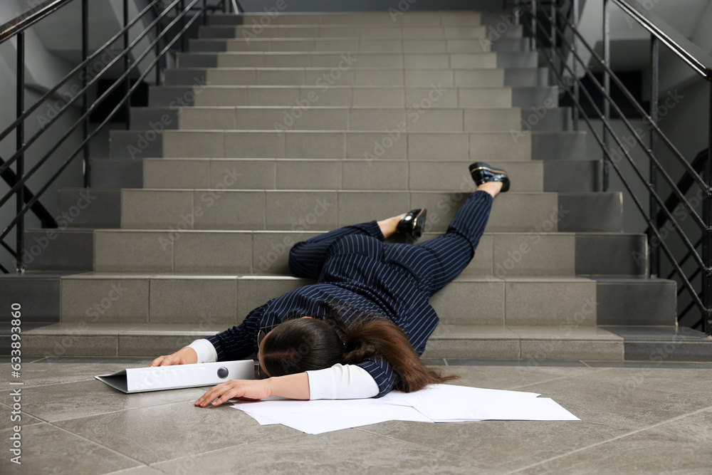 Unconscious woman with scattered folder and papers lying on floor after ...