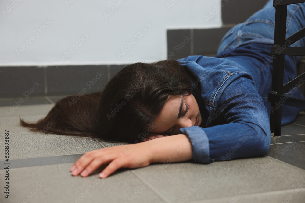 Unconscious woman lying on floor after falling down stairs indoors ...