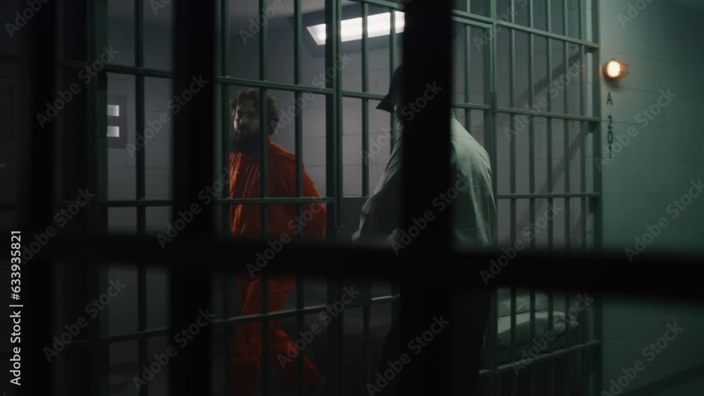 Video Stock Jailer walks the corridor. Male prisoner hits prison ...