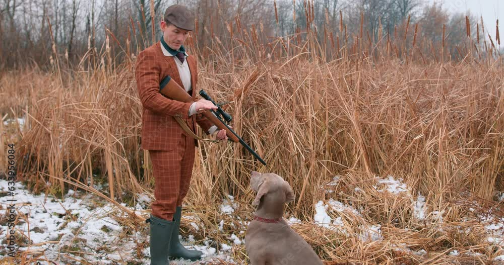 guy in traditional hunting clothes teaching dog, giving command ...