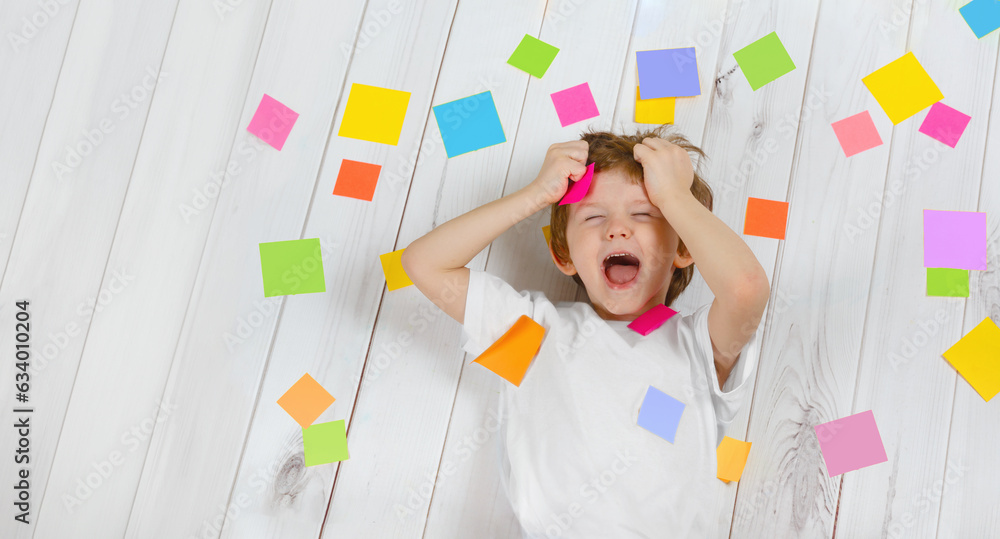 Crying child with sticky notes on clothes, forehead and around with ...
