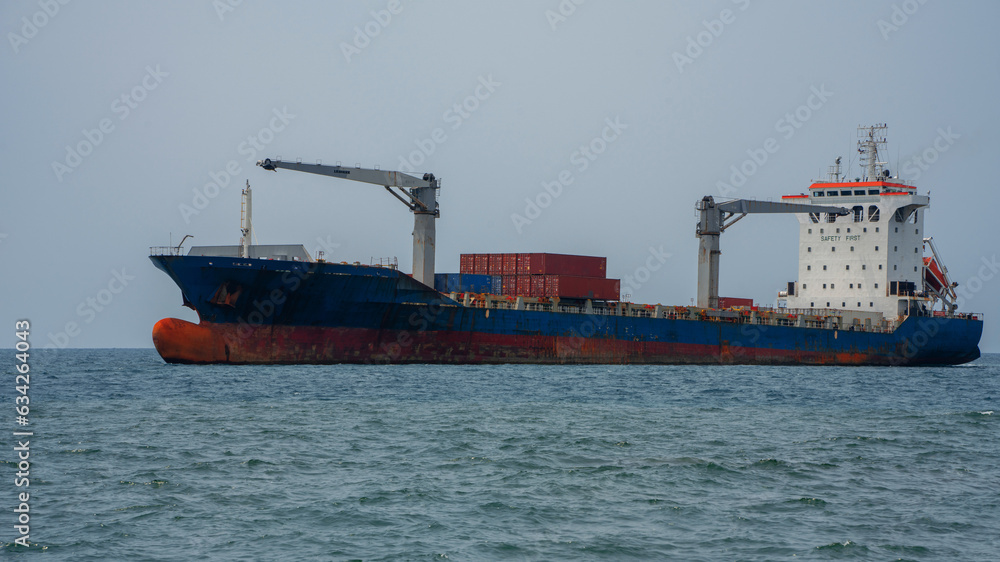 Side view of cargo ship carrying container and running near ...