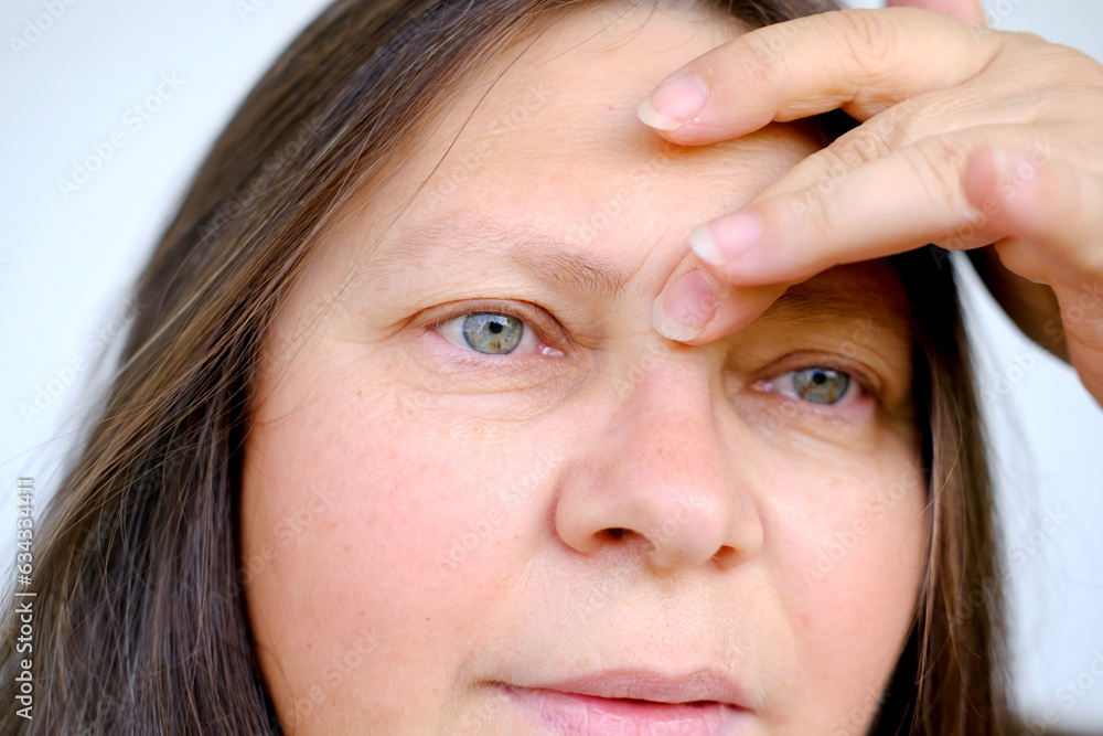 close-up of charismatic mature woman 50 years old looks carefully ...