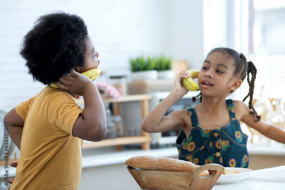 Cute little African boy pretends to use a banana to talk on the ...