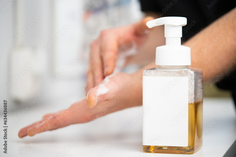 applying and rubbing the cosmetic product from the bottle into the hand ...