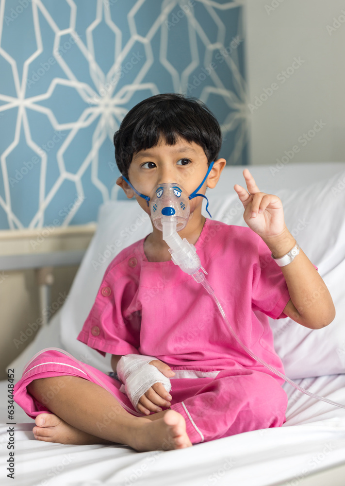 Sick boy inhalation therapy by the mask of inhaler. Baby has asthma and ...