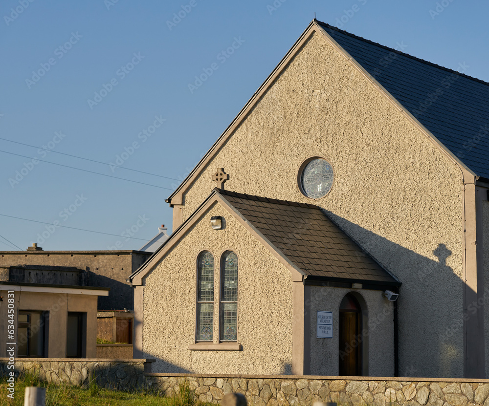 As the sun sets on the gable of a church, it casts a shadow of the ...