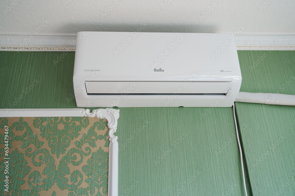 Indoor air conditioning unit on wall of apartment with green wallpaper ...