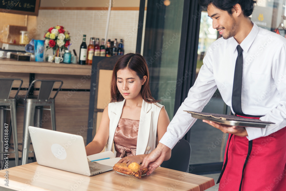 Restaurant business Handsome waiter serving food to young beautiful ...