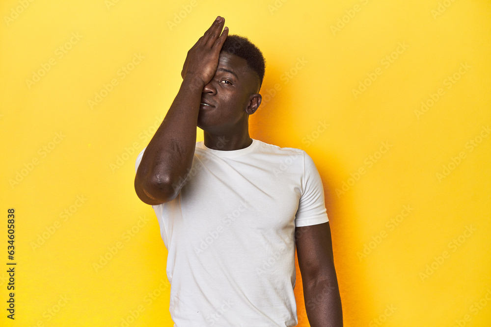 Stylish young African man on vibrant yellow studio background ...