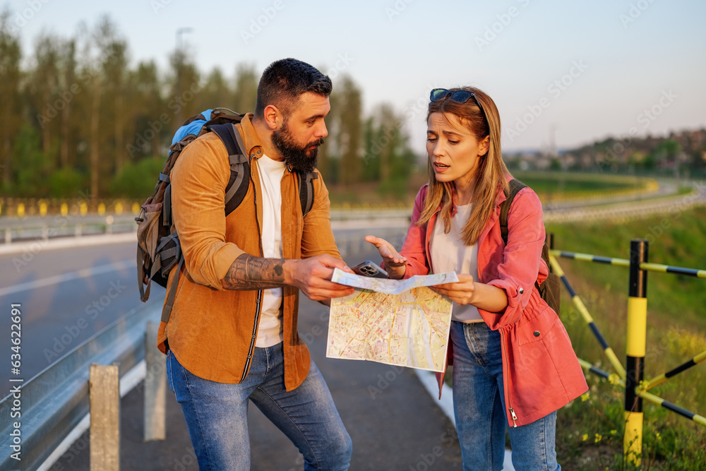 Tourists are using map in the city. They are sightseeing the city and ...