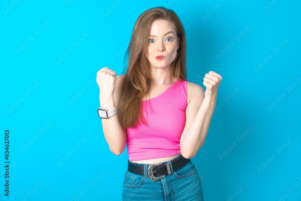 Irritated Young beautiful girl wearing pink T-shirt blows cheeks with ...