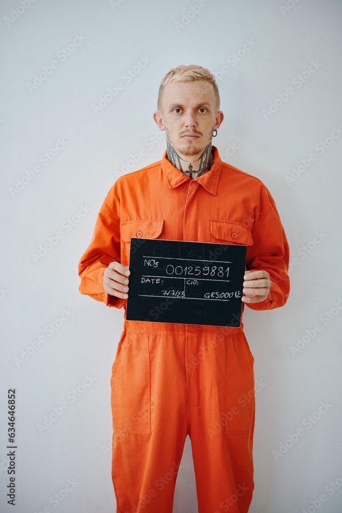 Mugshot of suspect in ornage uniform holding sign board Stock Photo ...