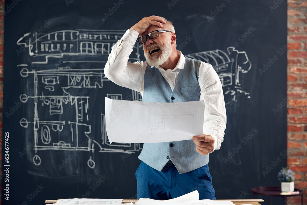 Unacceptable mistakes. Senior man, architect holding hand on head and ...