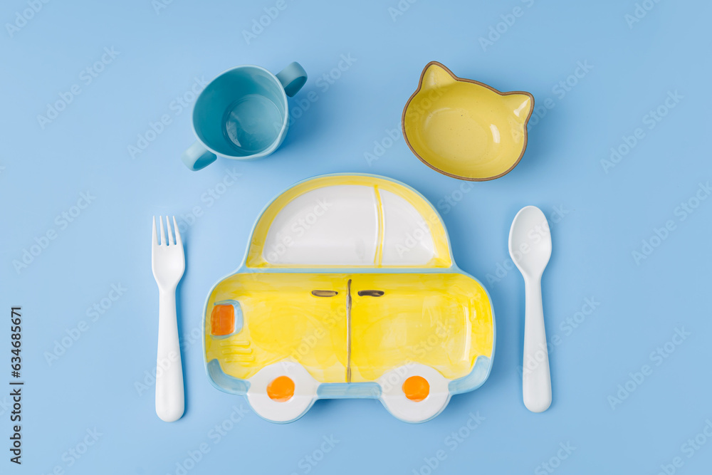 Cute children's plates and dishes shape of a car on blue background ...