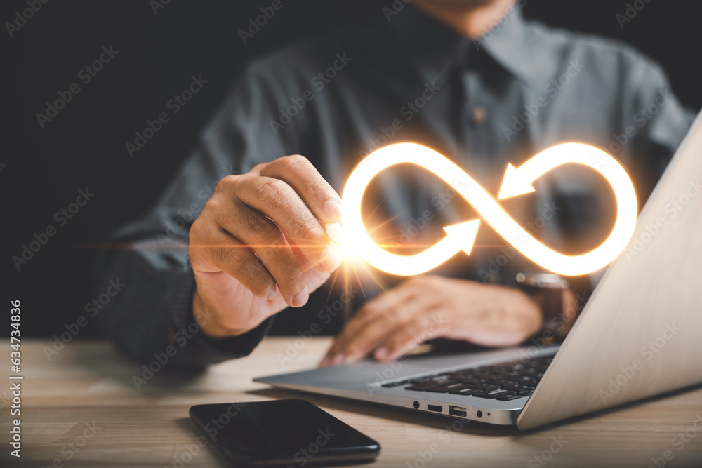 Businessman pointing at infinity symbol, symbolizing unlimited ...