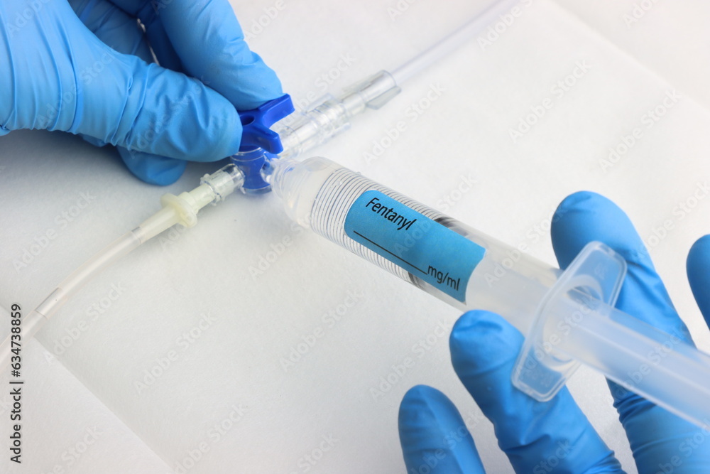 Professional wearing gloves injecting fentanyl opioid in a intravenous ...