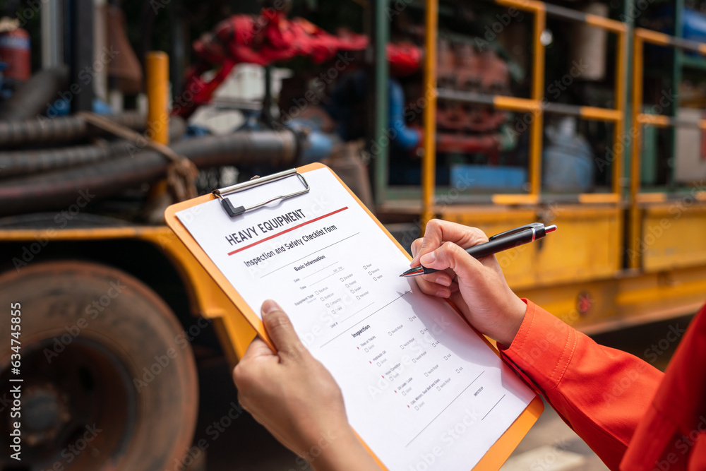 A mechanical engineer is checking on heavy machine and equipment ...