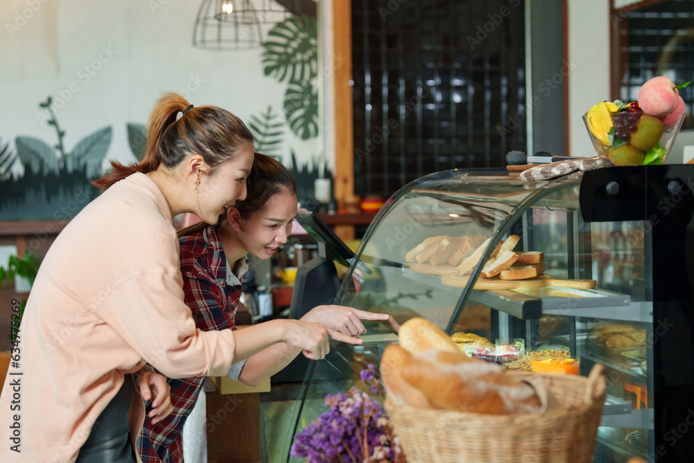 Customers who are close friends come to order cakes in cafe. pointing ...
