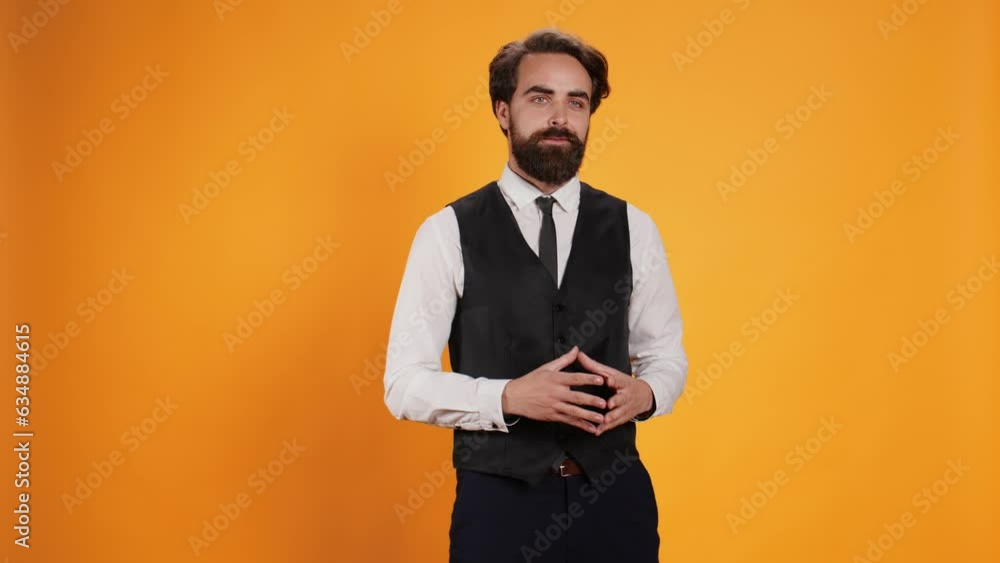 Skilled classy butler pointing aside and working at five star ...