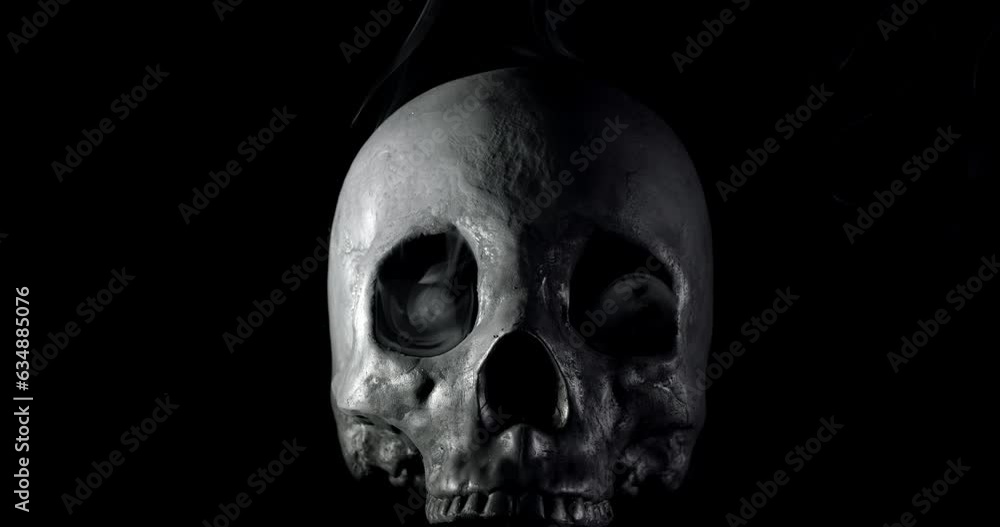 Spooky human skull with smoke creeping from it's eye sockets. Haunted ...