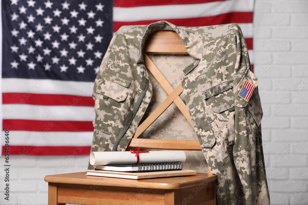 Chair with soldier uniform, notebooks and diploma near flag of United ...