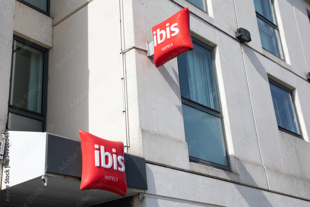 Ibis hotel chain brand text and sign red cushion logo on facade hostel ...